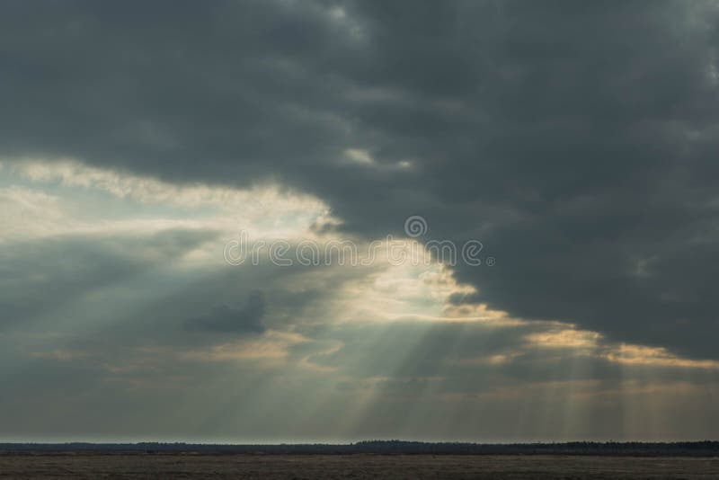 Sun Rays Streaming Down the Streaks of Dark Clouds. Stock Photo - Image ...
