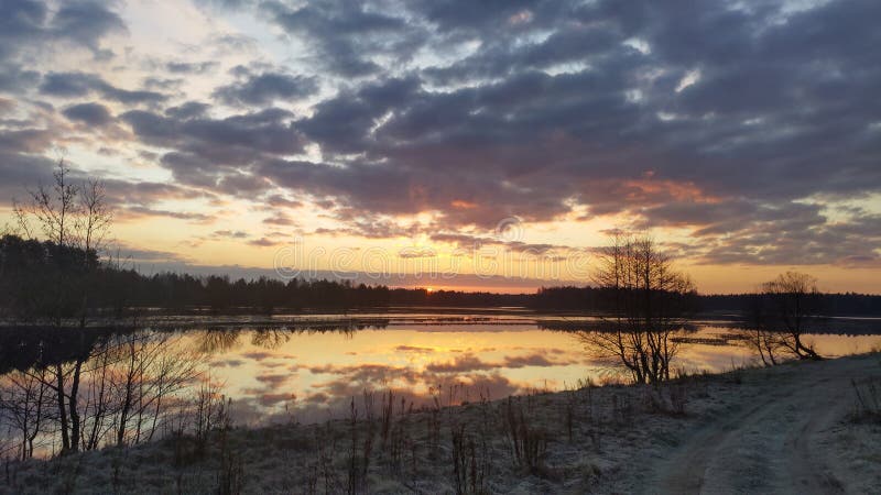 The Sun Rises from Behind the Forest on the Far Side of the Lake and ...