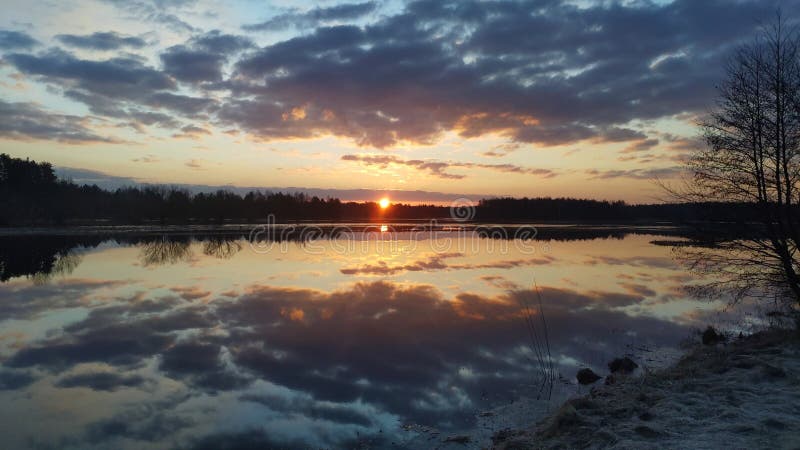 The Sun Rises from Behind the Forest on the Far Side of the Lake and ...