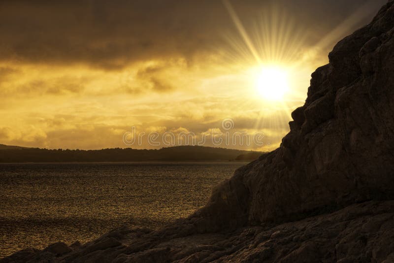The Sun Rising Behind the Rocks in the Lake Stock Photo - Image of ...