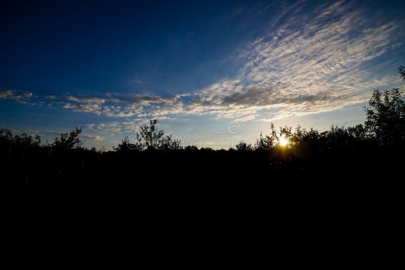 Sun Rising Over Trees in the Countryside with Moody Sky and Clouds ...