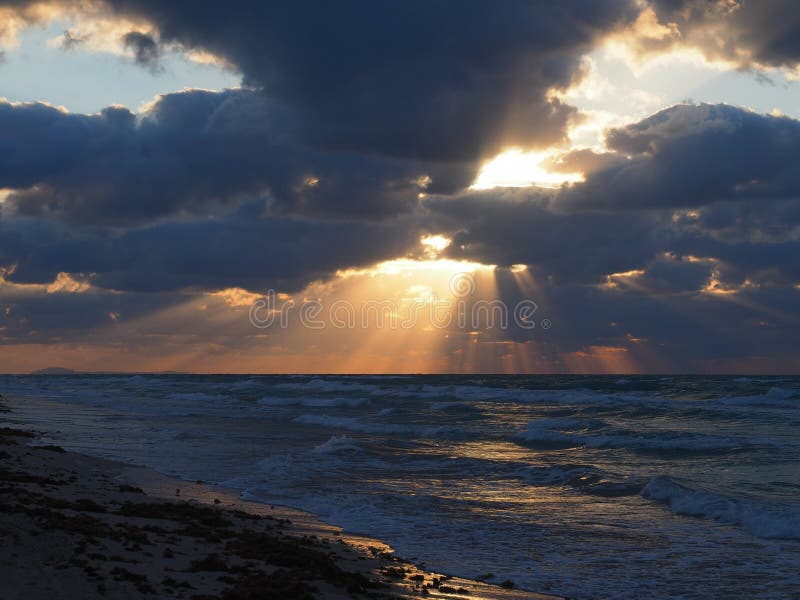 The Sun`s Rays Break through the Clouds Over the Sea Stock Photo ...