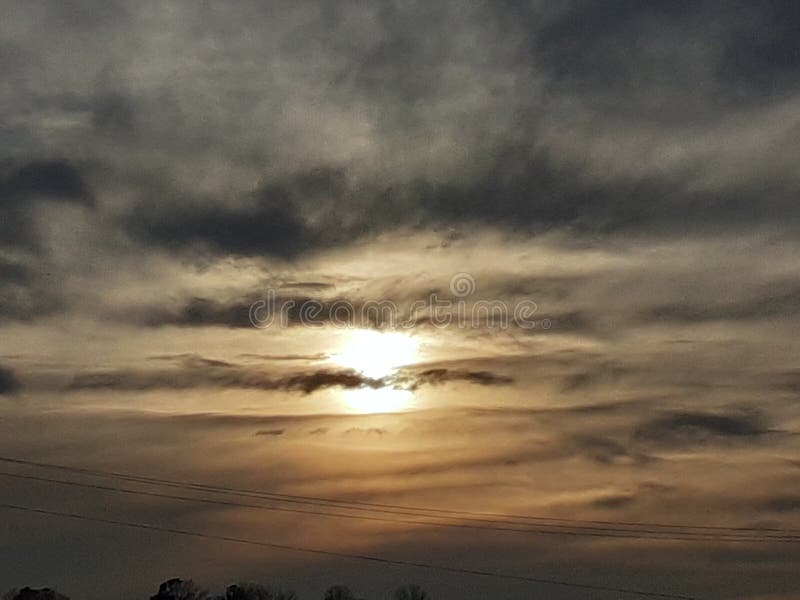 Sun Set Peeking through Clouds Yellow Grey Black Stock Image - Image of yellow, clouds: 164488285