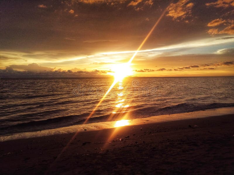 The sun sets on the beach stock photo. Image of beautiful - 219912176