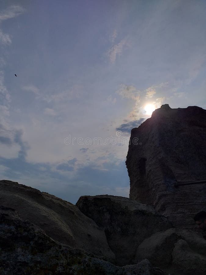 The Sun Sets Beautifully and Hides Behind a Rock Stock Image - Image of ...