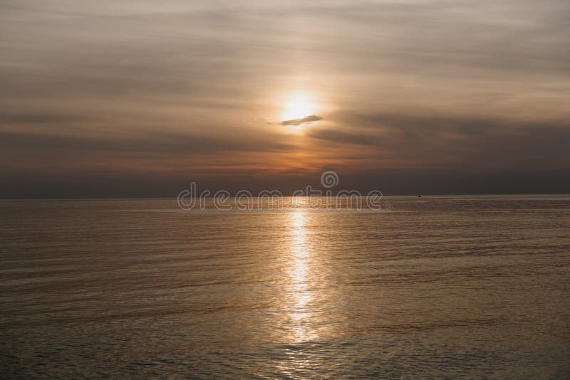 The Sun Sets Beautifully Over the Ocean, Reflecting in the Water Stock ...