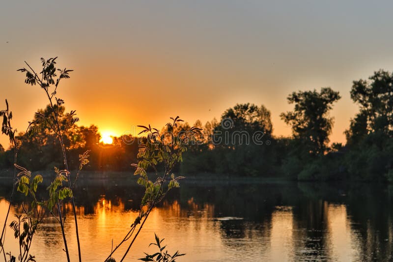 The Sun Sets Behind an Orange Sky and Silhouetted Electrical Tower ...
