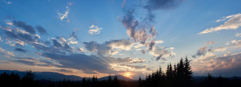 Sun Sets Behind Range of Distant Mountains, Casting Golden Rays through ...