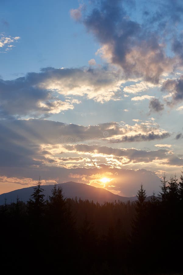Sun Sets Behind Range of Distant Mountains, Casting Golden Rays through ...