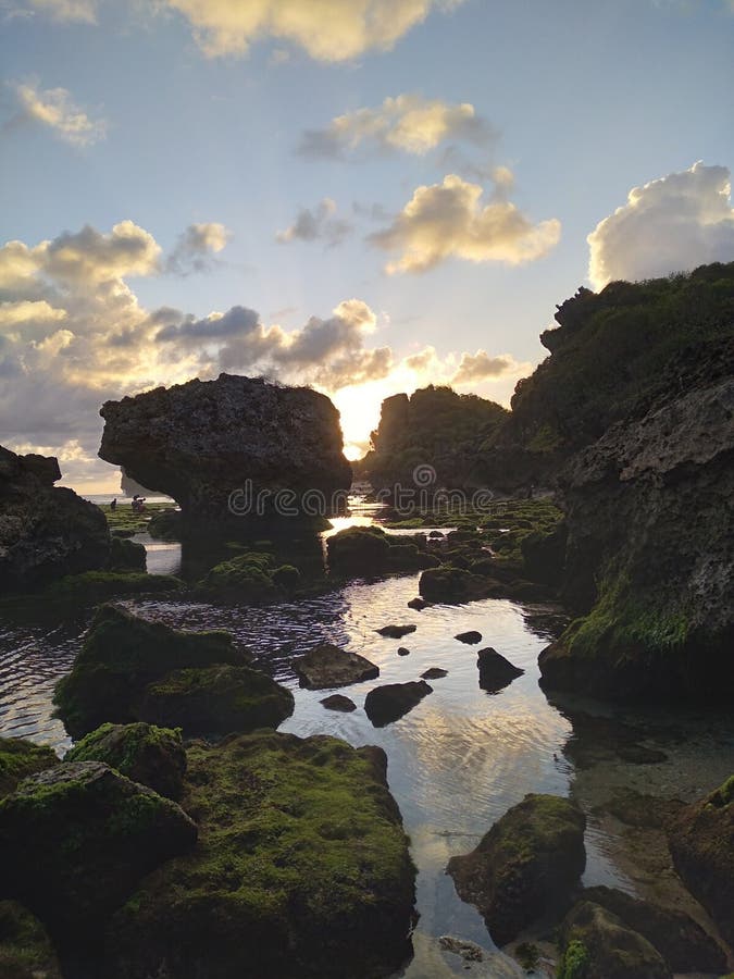 The Sun Sets Behind the Rocks on the Beach Stock Image - Image of beach ...