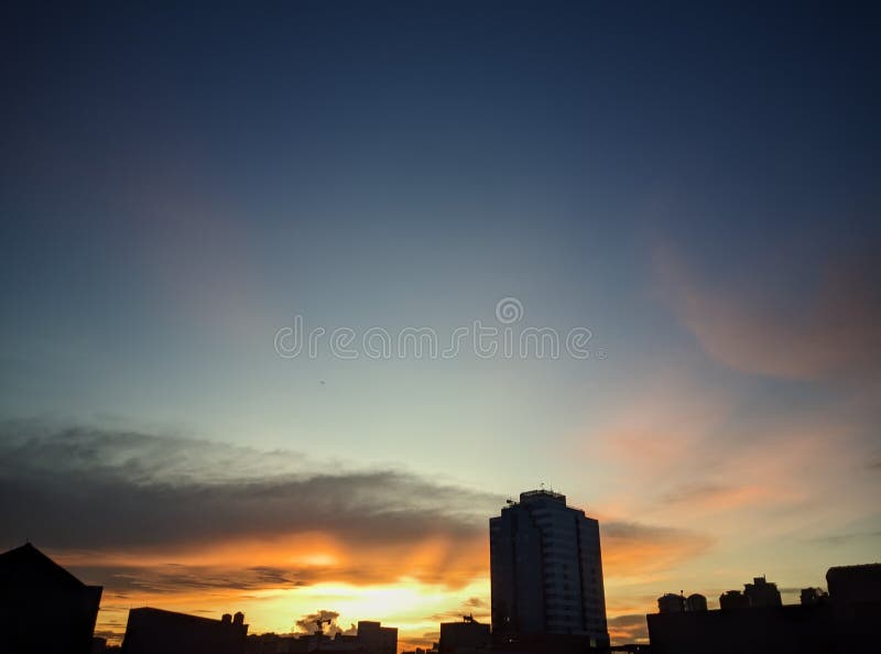 The Sun Sets Behind the Tall Buildings Stock Image - Image of blue ...