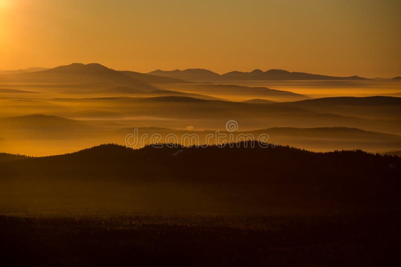 The Sun Sets Below the Horizon and Illuminates the Fog in the Valley ...