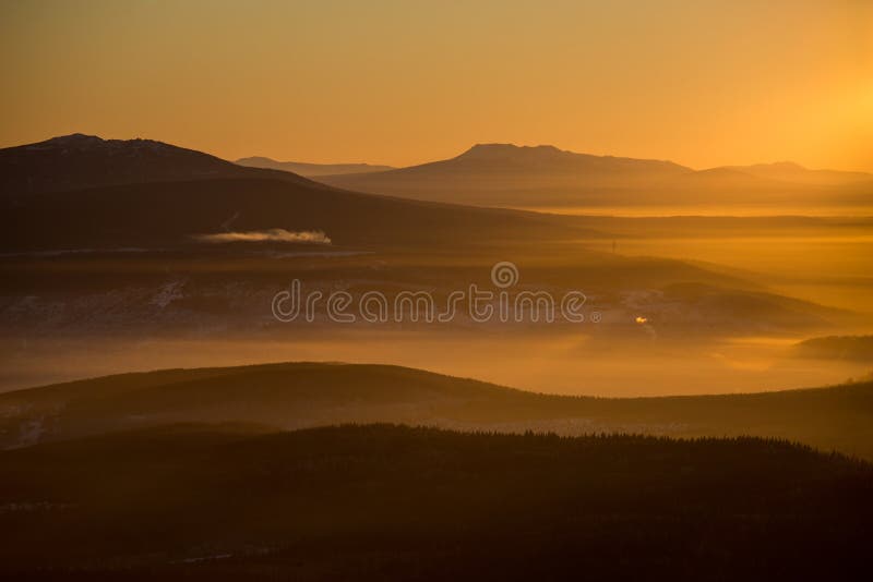 The Sun Sets Below the Horizon and Illuminates the Fog in the Valley ...