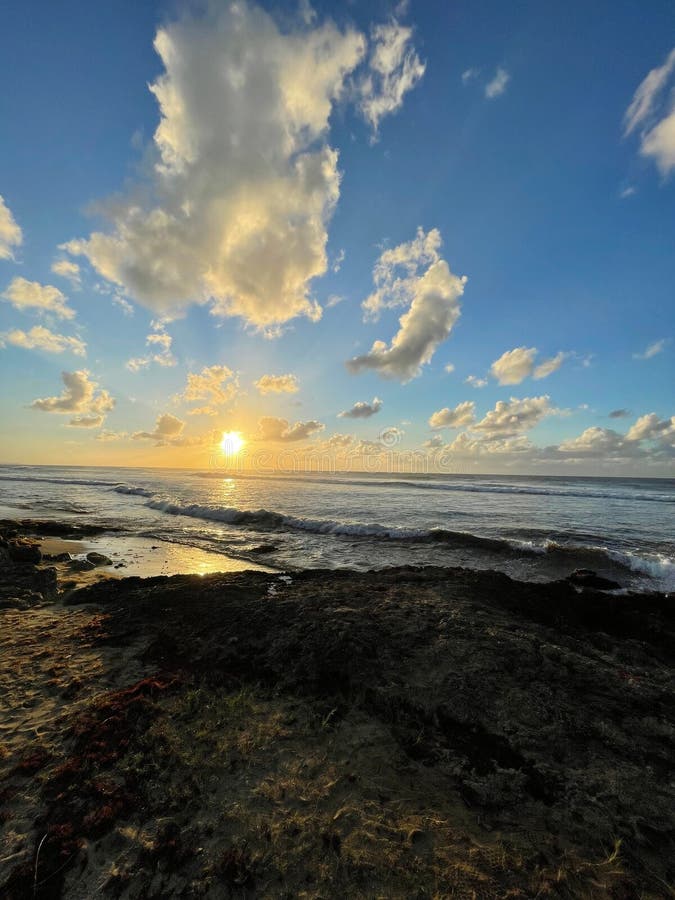 The Sun Sets Over the Ocean with the Clouds Above it Stock Photo ...