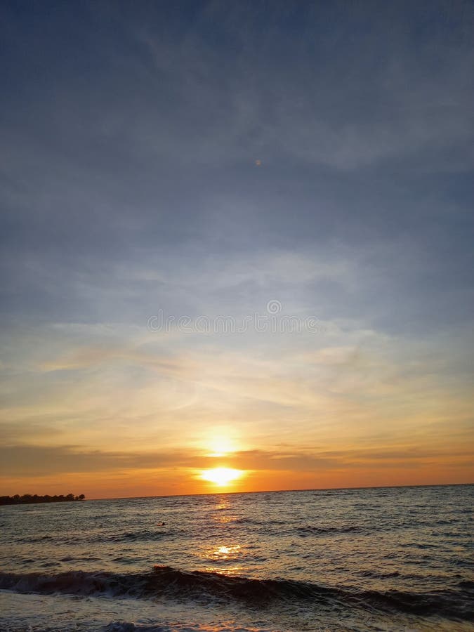 The Sun Sets Over the Ocean with Warmth Stock Photo - Image of sets ...