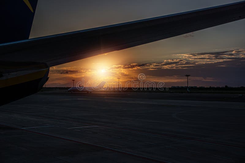 Sun Setting Behind Airplane Wing Stock Photo - Image of silhouette ...