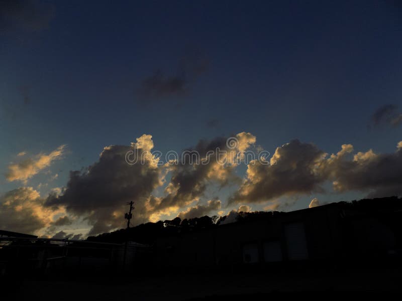 Sun setting behind clouds stock photo. Image of contrasting - 93380270