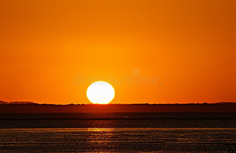 Sun setting in horizon stock photo. Image of orange - 100690272
