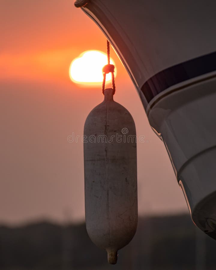 The Sun Setting Behind a Rubber Boat Fender on a Sailing Boat Stock ...