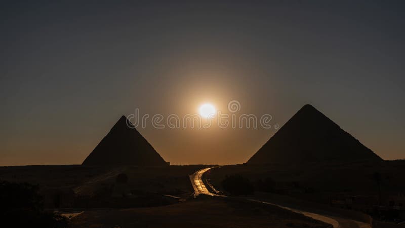 The Sun is Setting Behind the Three Pyramids in Giza, Egypt Stock ...