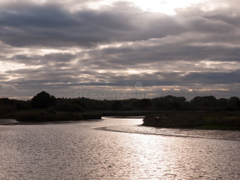Sun Setting through Dramatic Clouds and Onto Lake River Stream W Stock ...