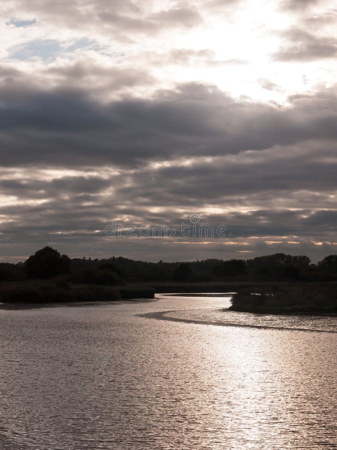 Sun Setting through Dramatic Clouds and Onto Lake River Stream W Stock ...