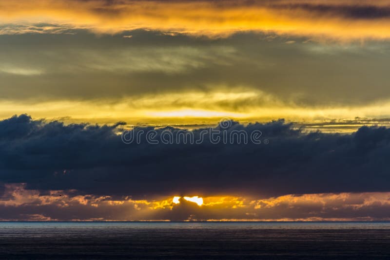 Sun Setting on the Horizon with Clouds Stock Photo - Image of water ...