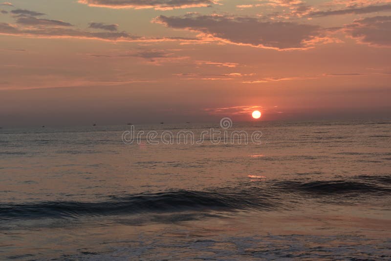 Sun Setting in a Ocean with Small Waves and Beautiful Sky Stock Photo ...