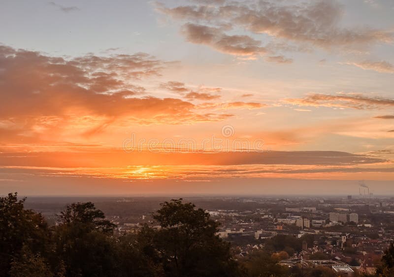 The Sun is Setting Over a City with a Beautiful Orange Sky Stock Photo ...