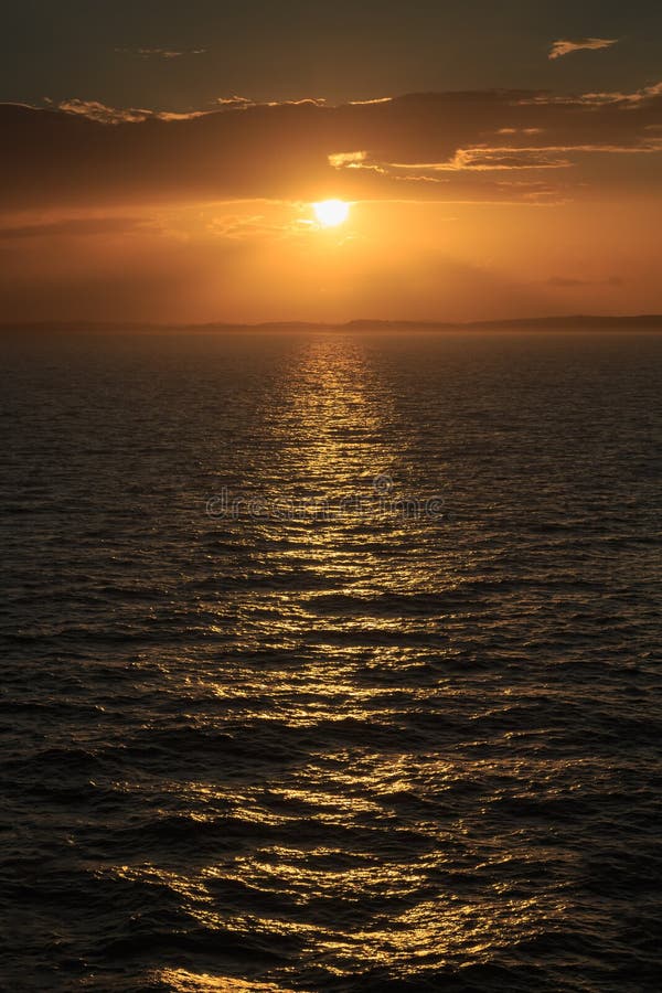 The Sun Setting Over a Darkening Ocean Stock Image - Image of clouds ...