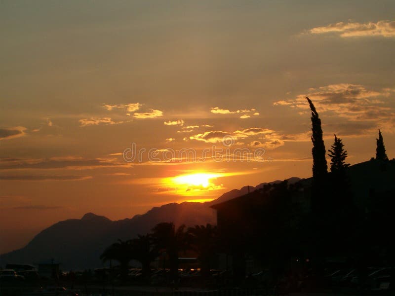 Sun setting over mountains stock photo. Image of sundown - 84879414