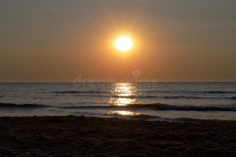 The Sun Setting Over the Ocean from a Beach Side Setting Stock Photo ...