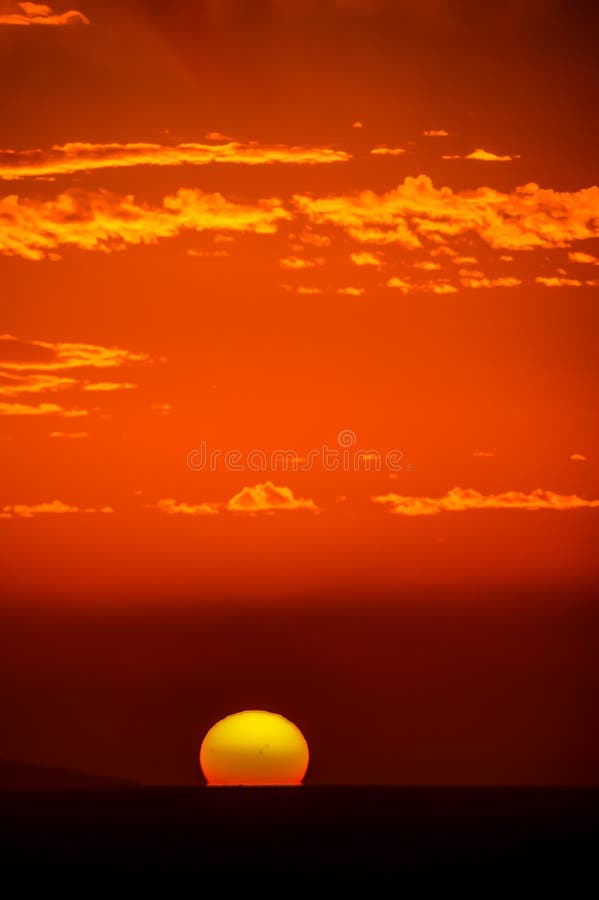 A Sun is Setting Over the Ocean, Casting a Warm Orange Glow Over the ...