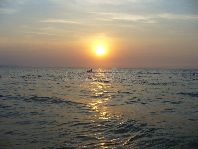 Sun setting over the ocean stock photo. Image of setting - 183063930