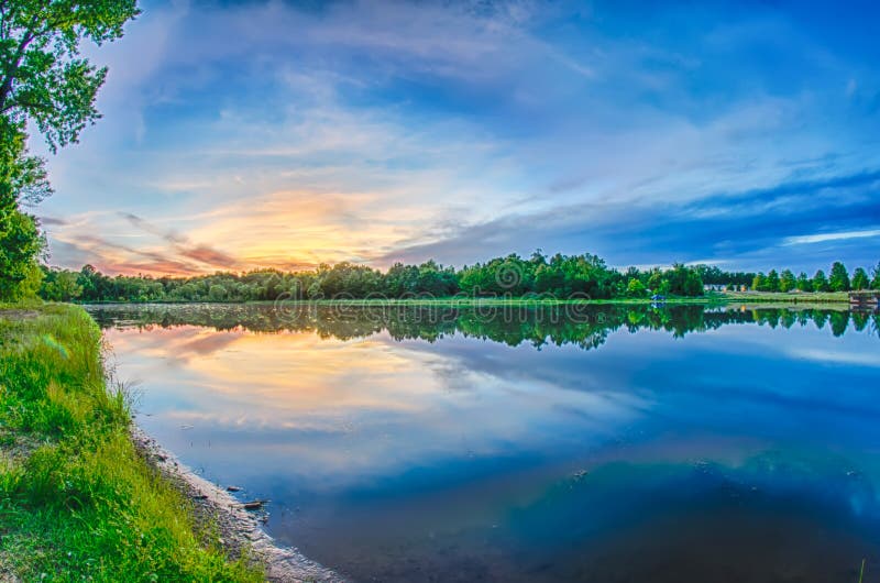 Sun Setting Over a Reflective Lake Stock Image - Image of outdoors ...