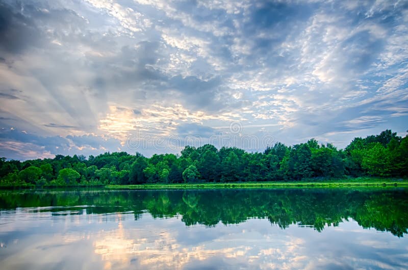 Sun Setting Over a Reflective Lake Stock Photo - Image of view, dawn ...