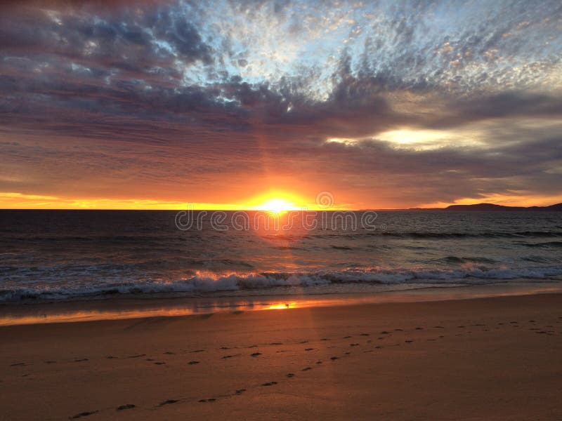 Sun setting over the sea stock photo. Image of beach - 78396012