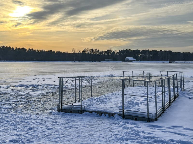 The Sun Setting Over a Snow-covered Beach and a Frozen Pond. a Boat ...
