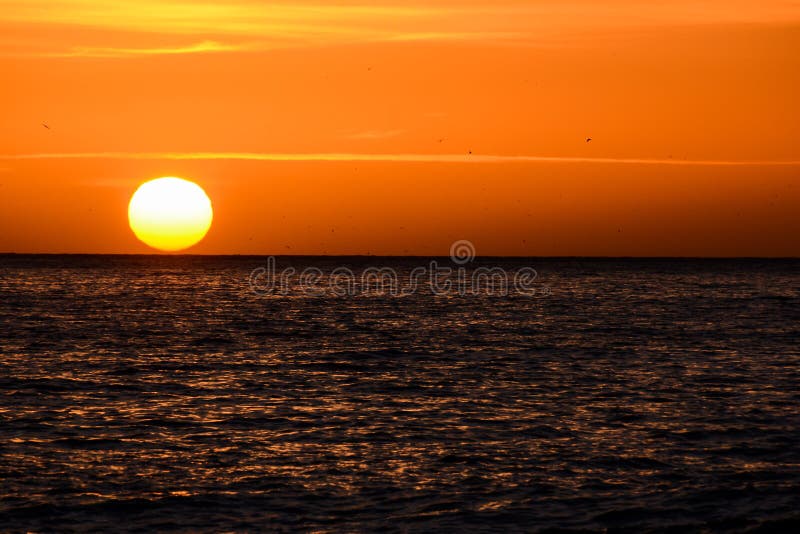 The Sun Setting in the Sea stock photo. Image of sunset - 186913120