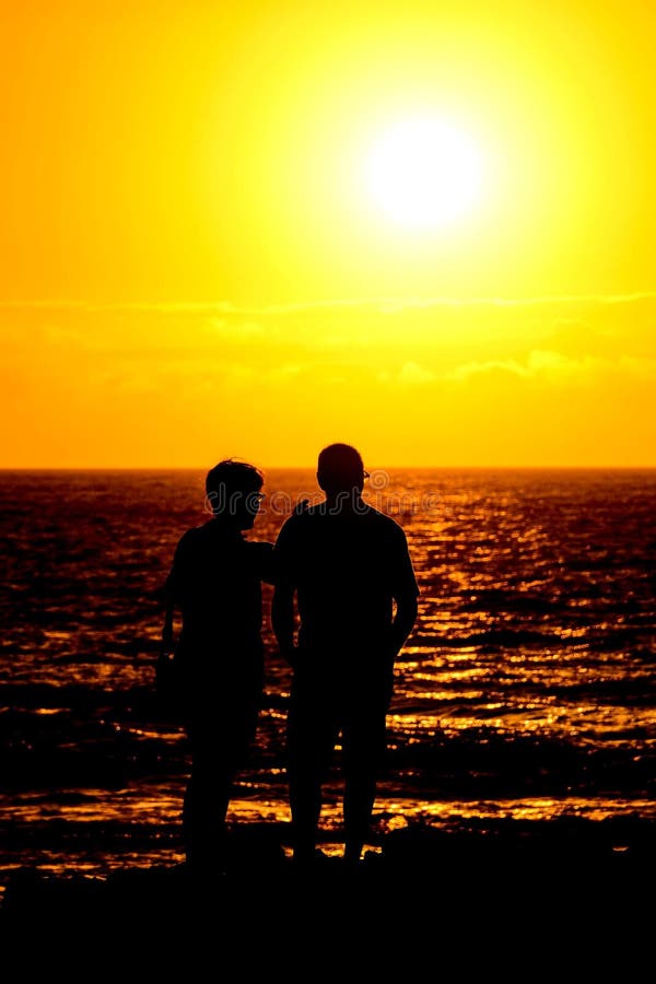The Sun Setting in the Sea stock image. Image of couple - 261556849