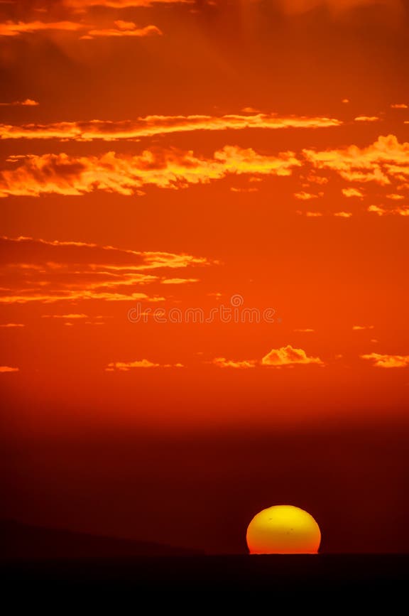 A Sun is Setting in the Sky, with a Large Orange Cloud in the ...