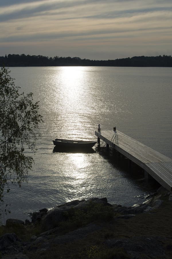 Sun Settting Over Lake with Jetty and Boat Stock Photo - Image of lake ...