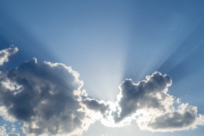 Sun Shines Behind the Clouds, Rays and Shadows on Blue Sky. Stock Photo ...