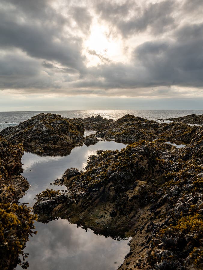 Sun Shining through Clouds Reflecting in Tide Pools on Rocky Coastline ...