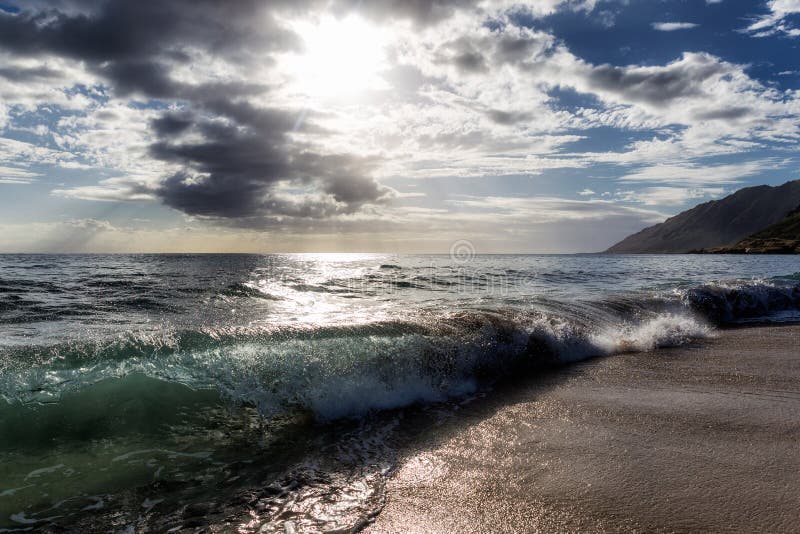 Sun Shining through the Clouds at Sandy Beach with Waves Stock Image ...