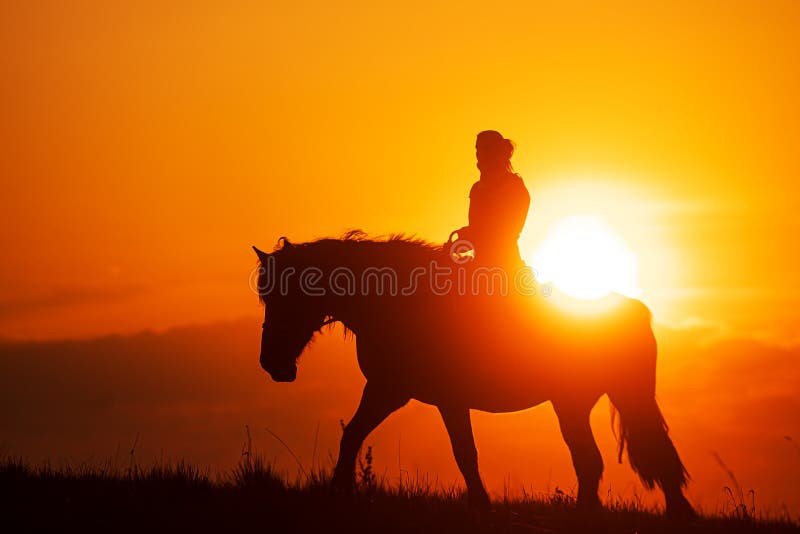 The Sun is Shining through Silhouette of a Woman Riding a Horse Stock ...