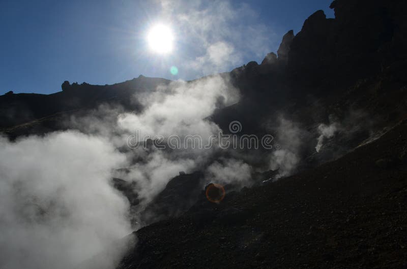 Sun Shining on Volcanic Rock with Steam Rising Stock Photo - Image of ...