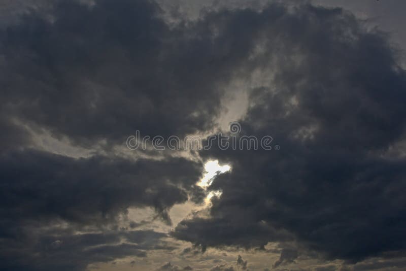 Sun Spot Peeping through Dark Storm Clouds Stock Photo - Image of ...