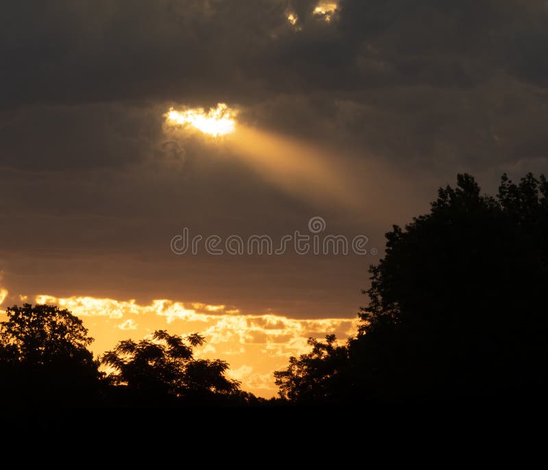 Sunbeam of Light Blasting through a Hole in Thick Clouds Stock Photo ...