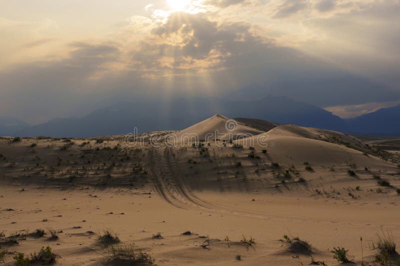 Sunbeams Over Desert Dunes with Tire Tracks Stock Photo - Image of ...